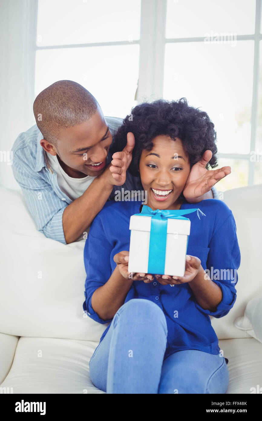 Surprised woman looking at gift on her hands Stock Photo - Alamy