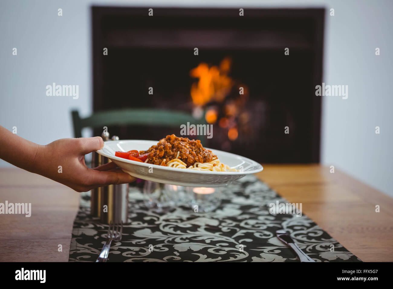 Person putting spaghetti on table Stock Photo - Alamy