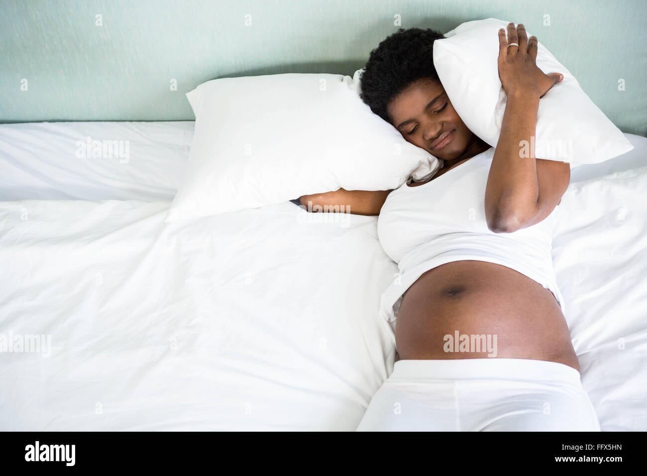 Pregnant woman covering her ears Stock Photo - Alamy