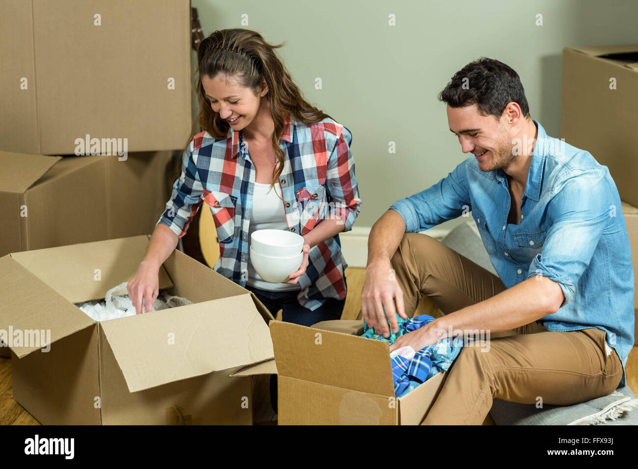 Young couple unpacking carton boxes Stock Photo - Alamy