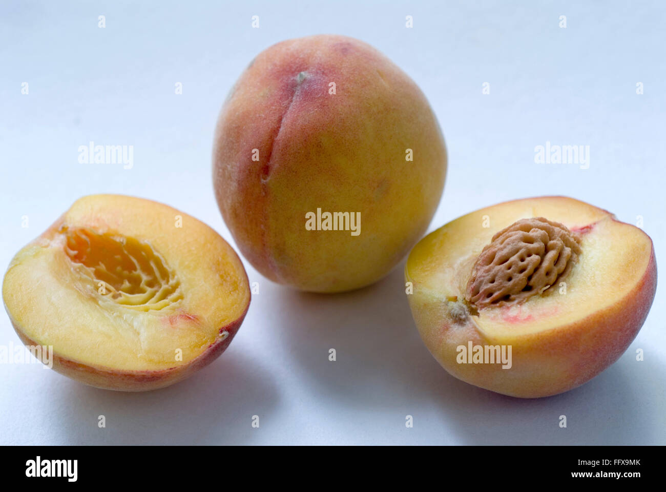 Peaches two cut in half fruits white background Stock Photo - Alamy
