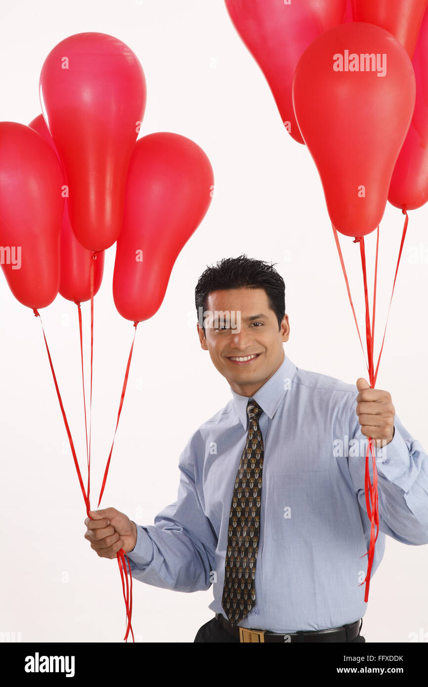 Businessman holding red color gas balloons in both hands MR#703T Stock ...