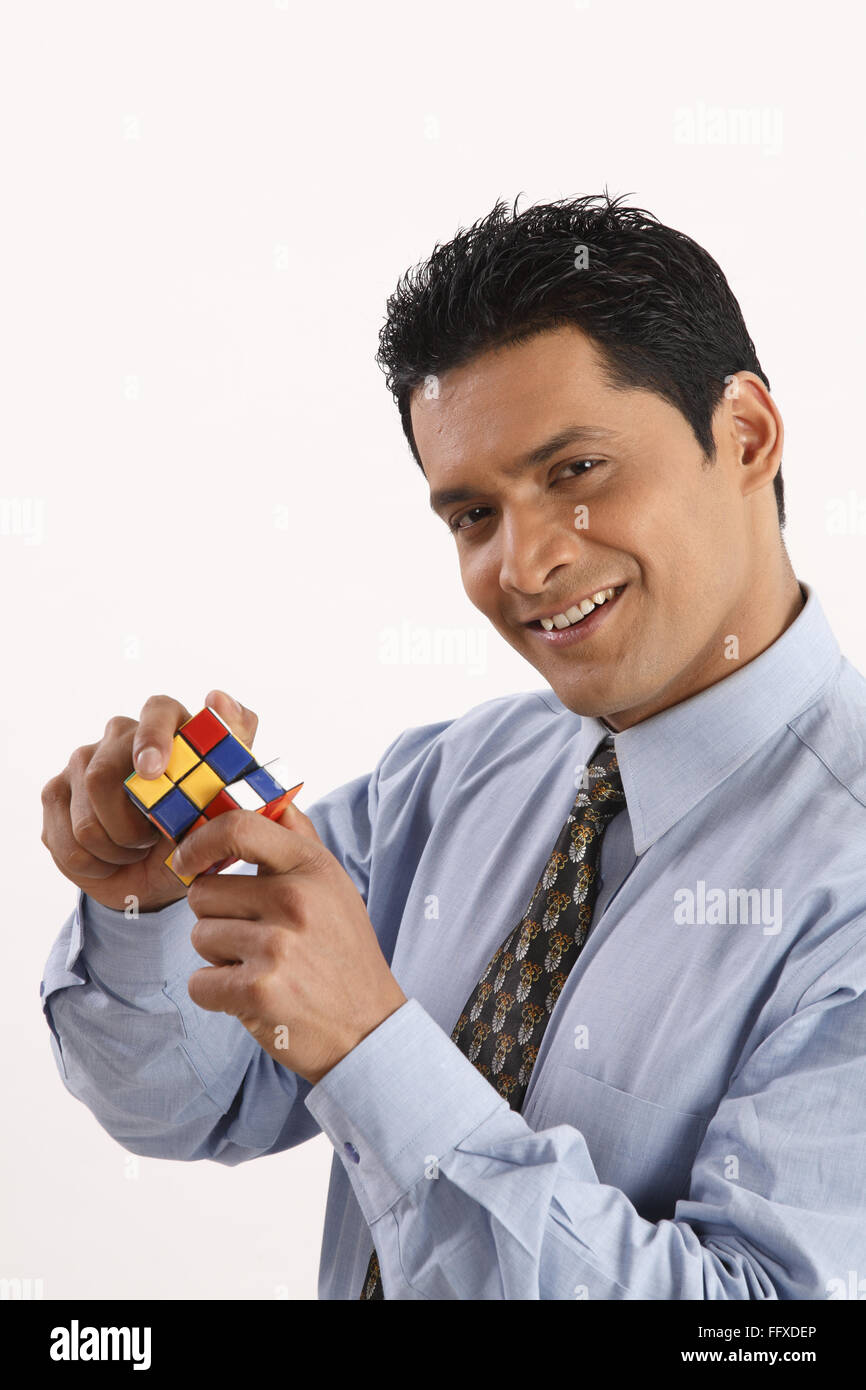 Businessman holding Rubik cube thinking it is easy to solve problem MR ...