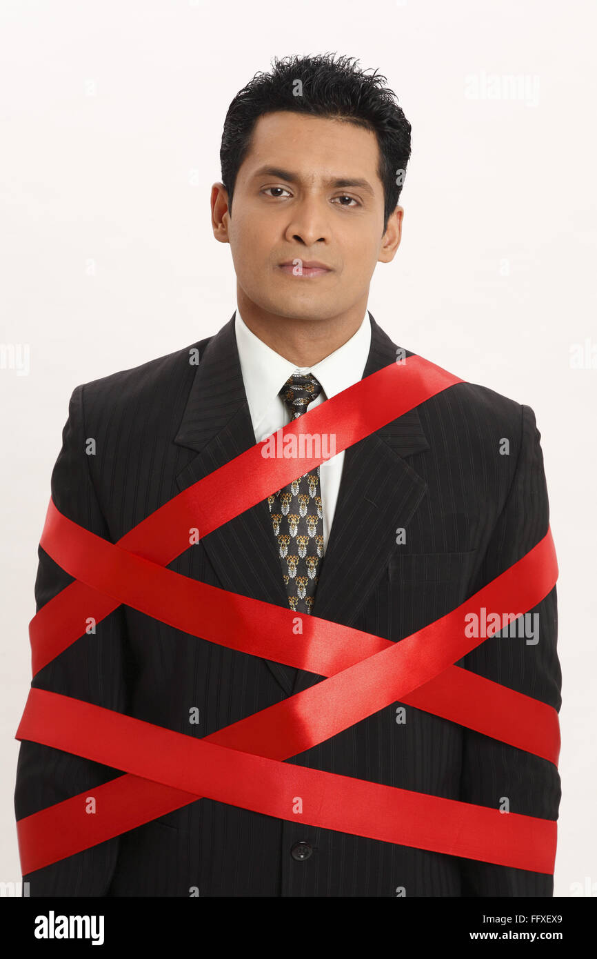 Businessman tied with red ribbon MR#703T Stock Photo - Alamy