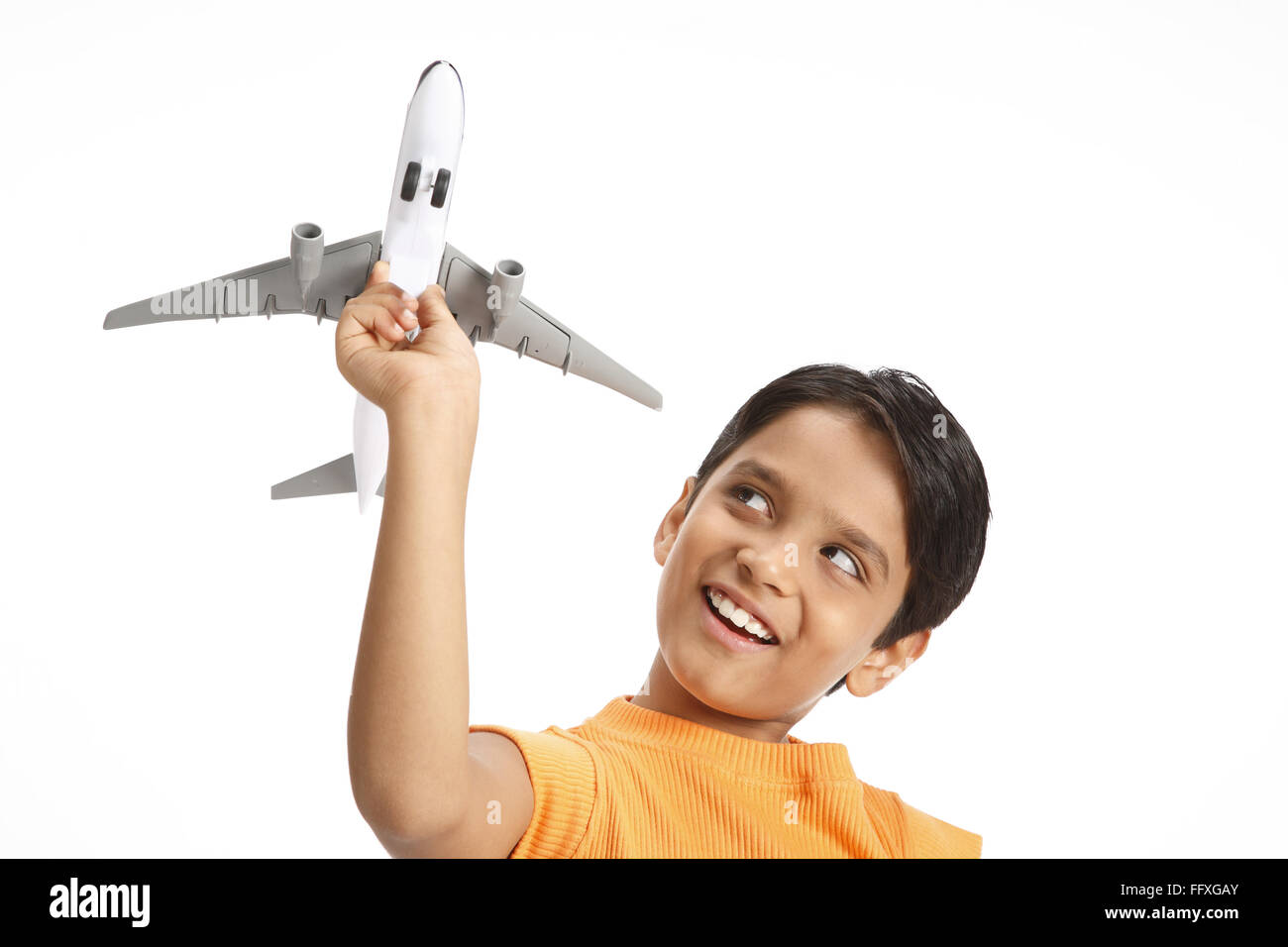 Ten year old boy holding toy plane in hand and trying to fly it MR#703V ...