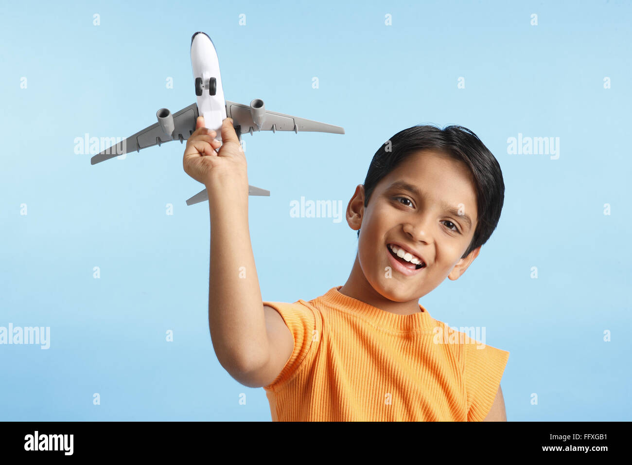 Ten year old boy holding toy plane in hand and trying to fly it MR#703V ...