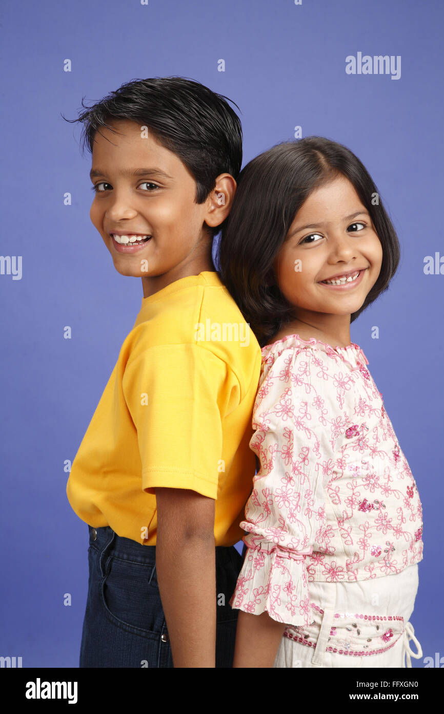 Ten and eight year old boy and girl standing back to back MR#703U,703V ...