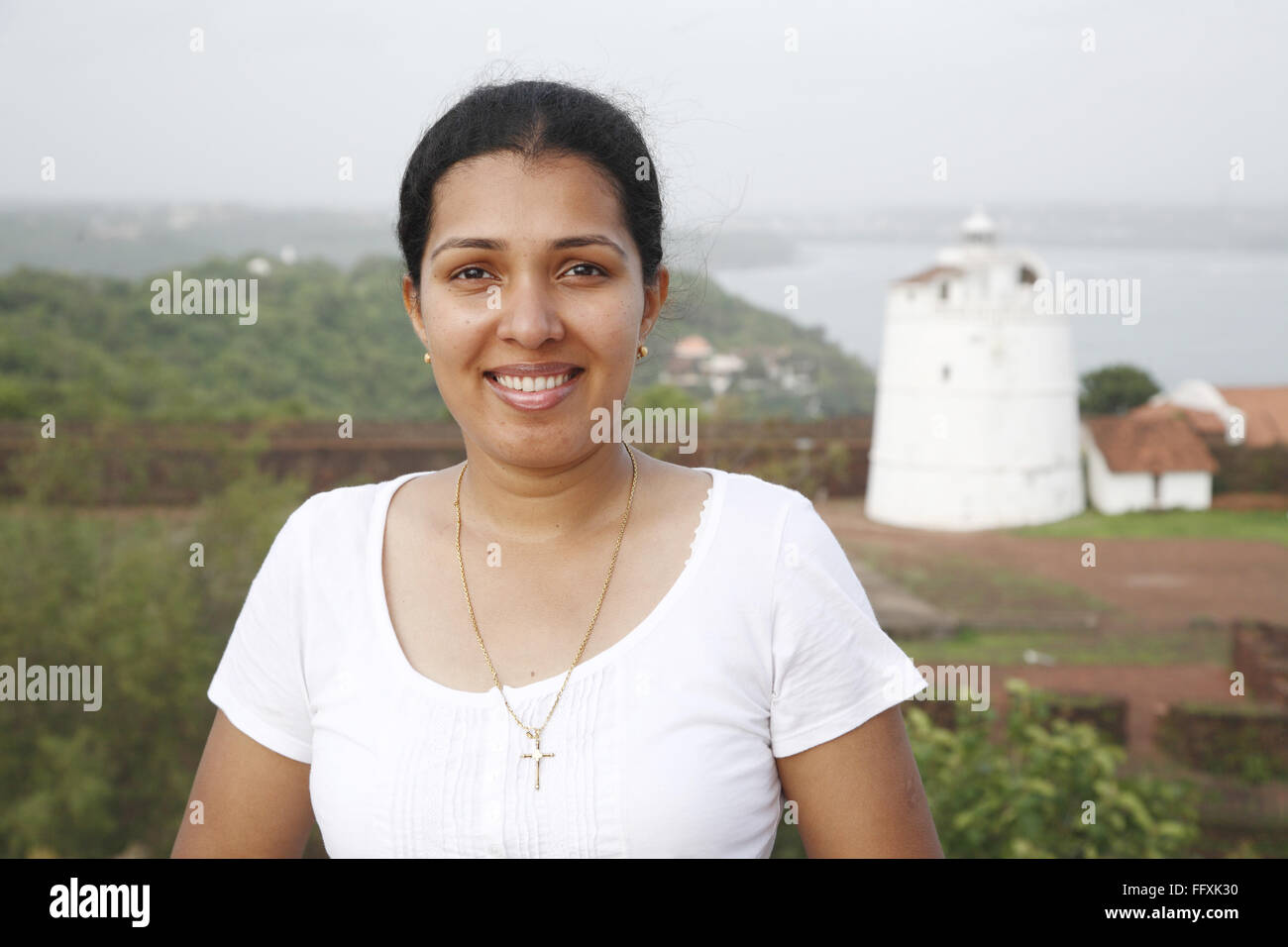 Lady smiling , Lighthouse of Fort Aguada in background , Goa , India MR ...