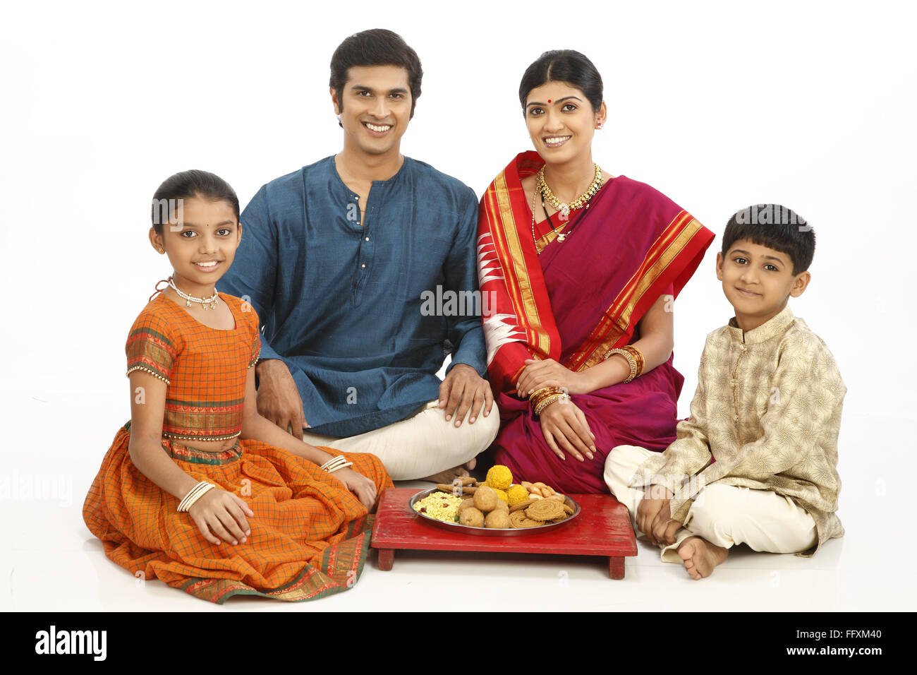 Rich rural farmer family sitting together with snacks kept in plate on ...