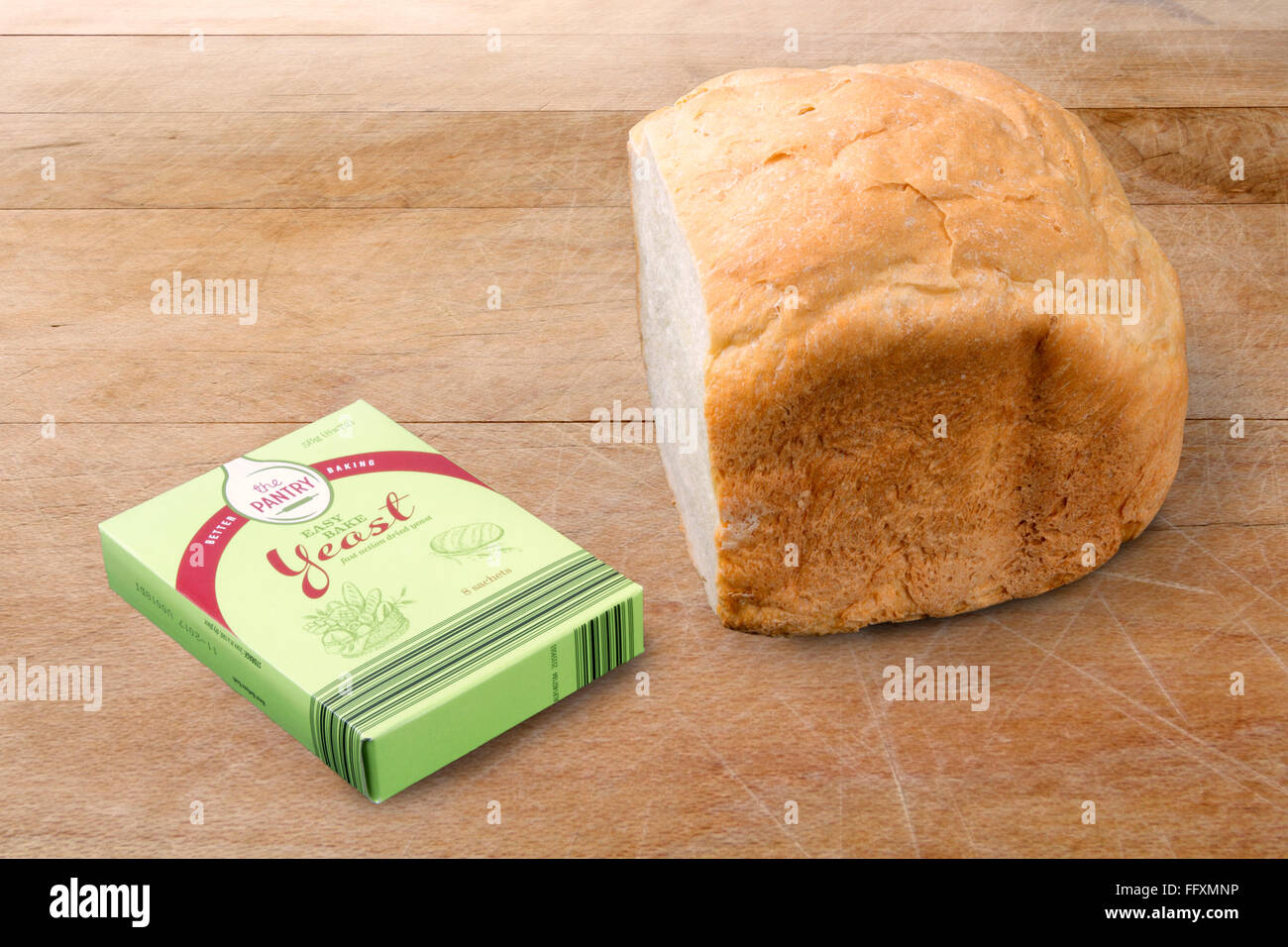 Home baked loaf of bread with a carton of powdered baking yeast sachets ...