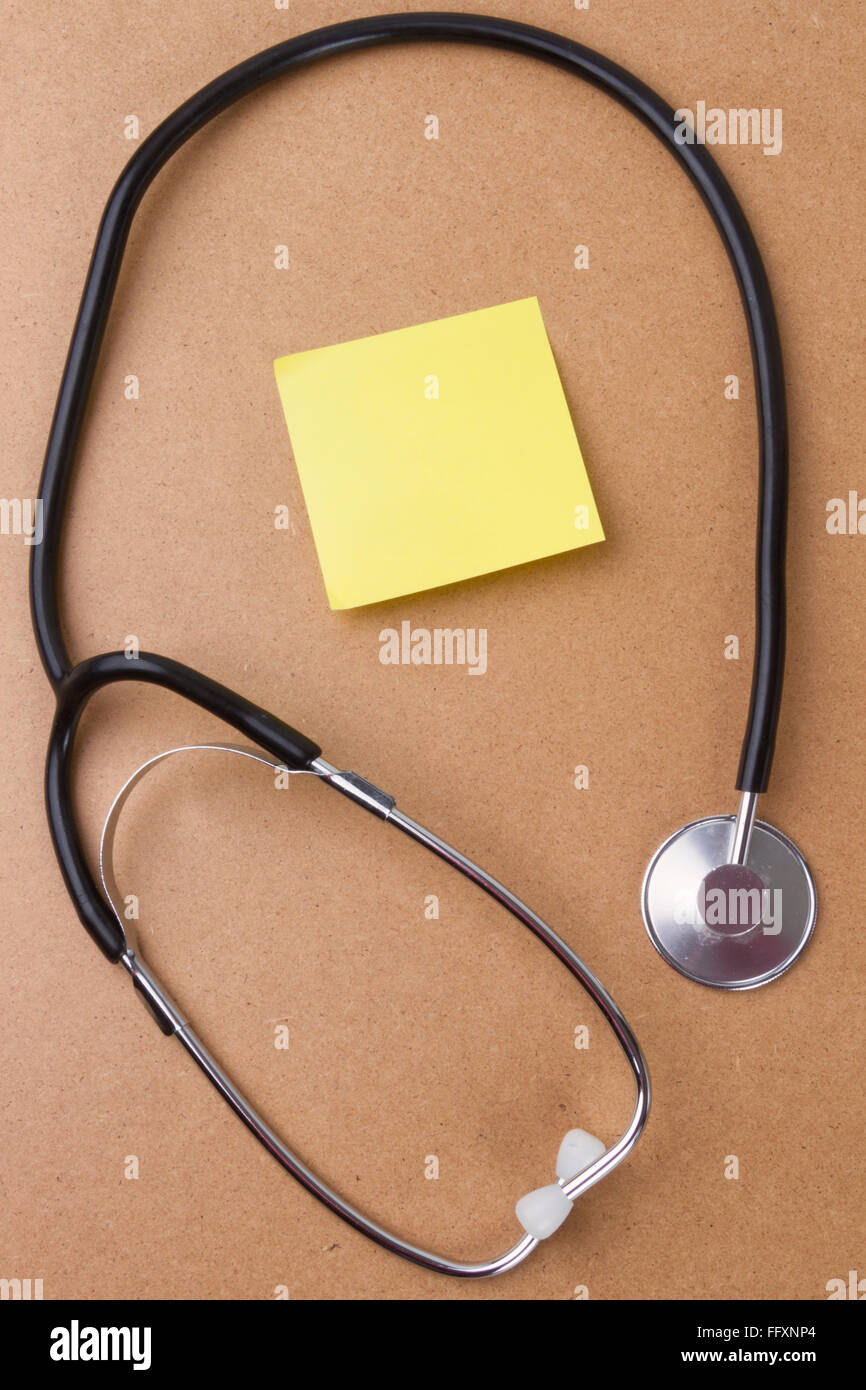 Stethoscope and a plain yellow sticky note on a wooden background Stock ...