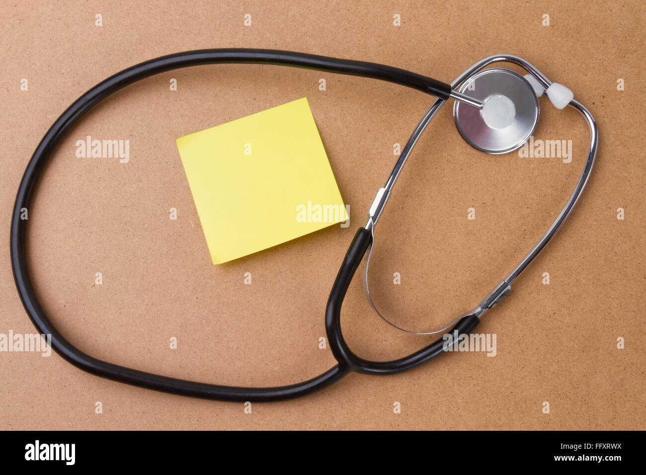 Stethoscope and a plain yellow sticky note on a wooden background Stock ...