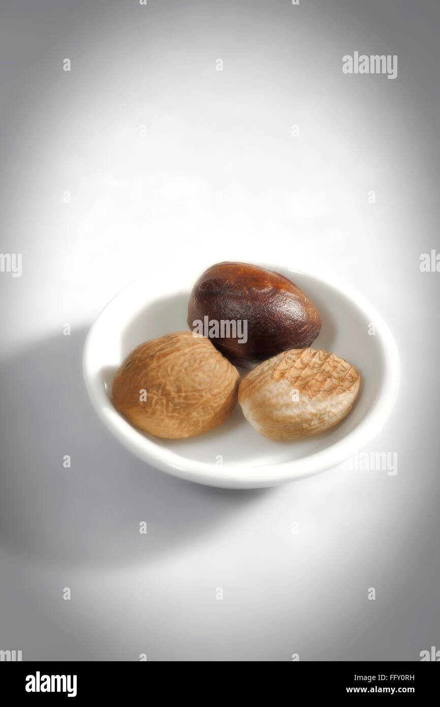 Nutmeg in bowl on white background Stock Photo - Alamy
