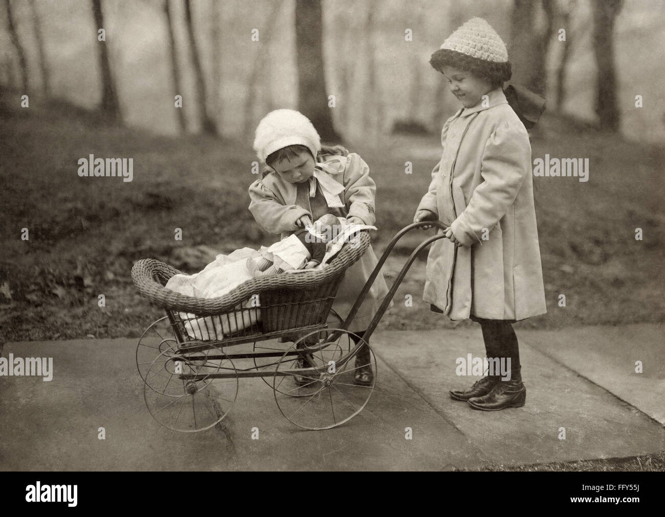 HINE: CHILDREN, 1912. /nTwo young girls playing with a Campbell Kid ...