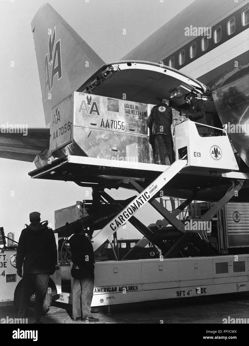 AMERICAN AIRLINES CARGO. /nMen loading cargo onto a Boeing 747 airplane ...