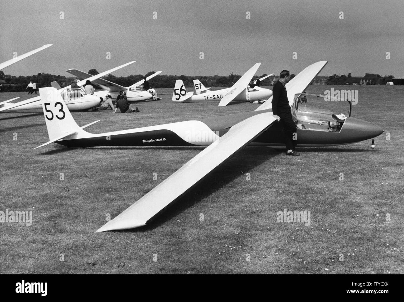 GLIDER COMPETITION. /nA man standing beside a Slingsby Dart 15 glider ...
