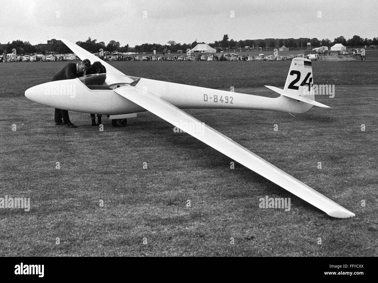 GLIDER COMPETITION. /nTwo men inspecting a single-seat glider at a ...