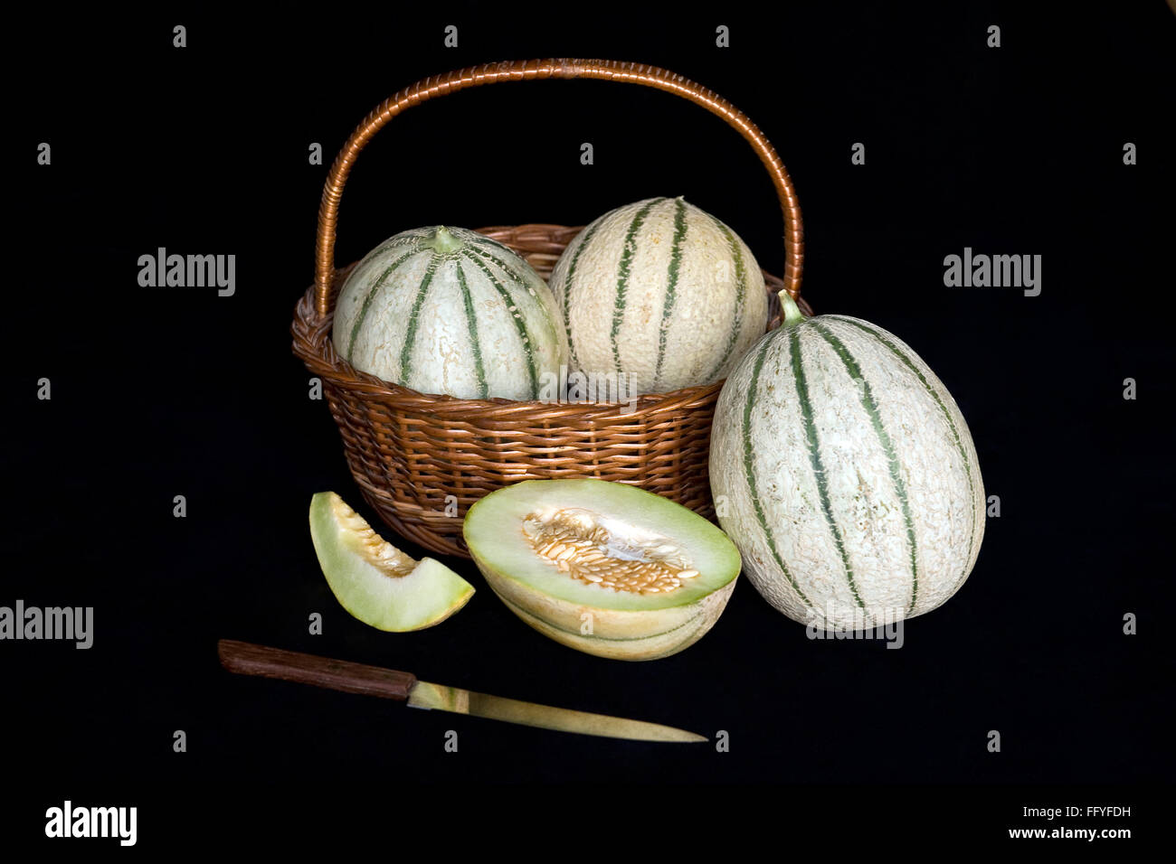 Three full and one cut charentais melon with cane basket ; India Stock ...
