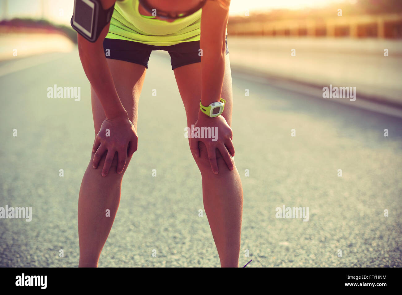 tired woman runner taking a rest after running hard on city road Stock ...