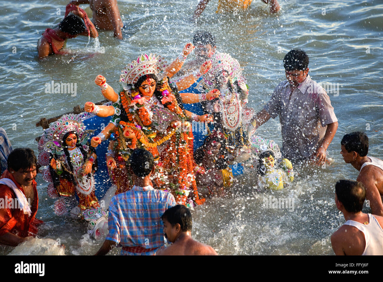 People sprinkling water on goddess durga Idol in ganga river on durga ...