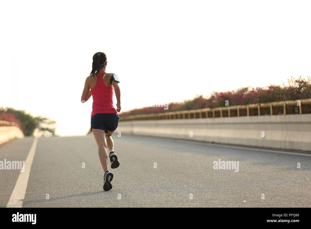 young woman runner running on city bridge road Stock Photo - Alamy