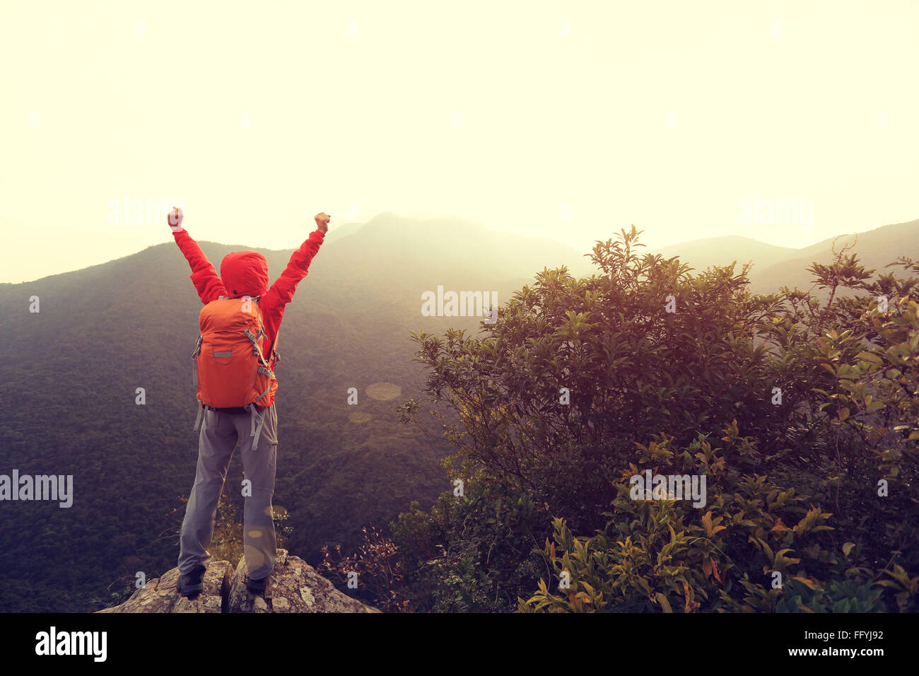 cheering woman hiker open arms at mountain peak cliff Stock Photo - Alamy
