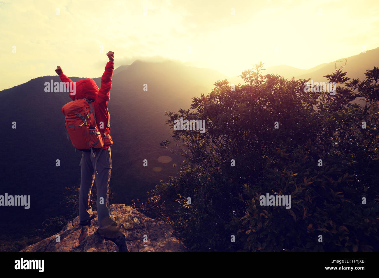cheering woman hiker open arms at mountain peak cliff Stock Photo - Alamy