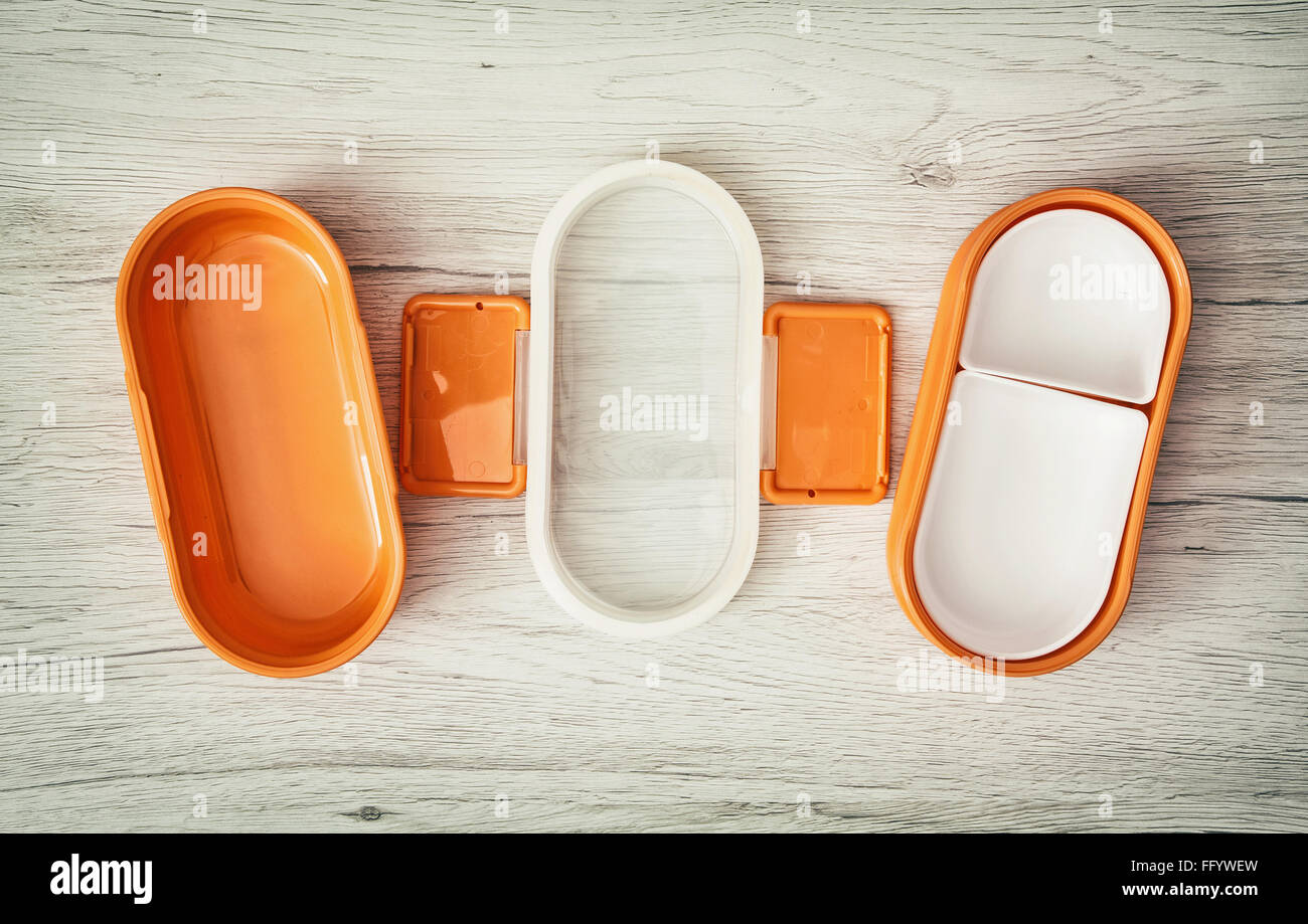 Orange folding plastic box for food storage on the wooden background ...