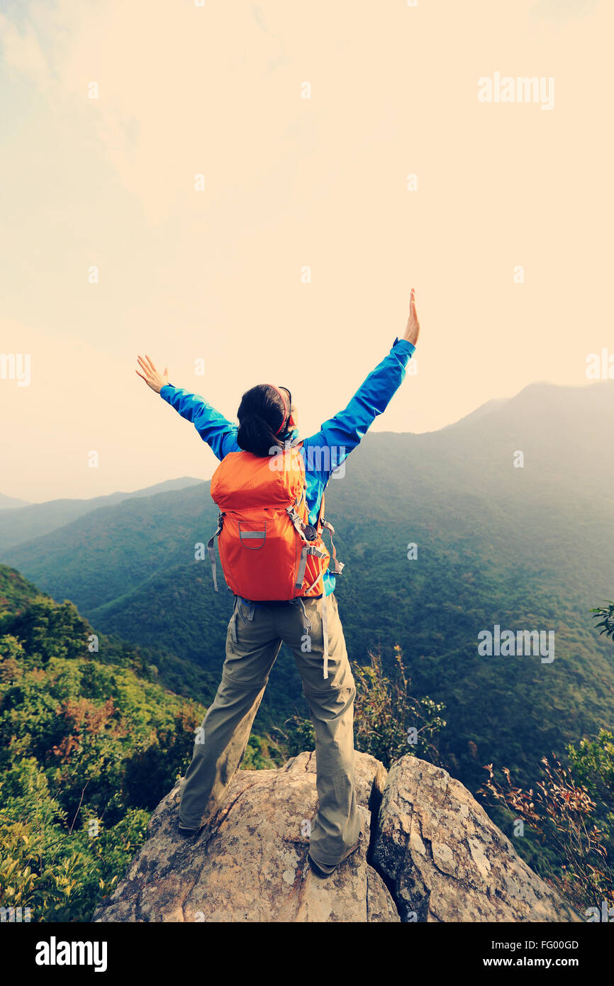 cheering young woman hiker open arms on mountain peak Stock Photo - Alamy