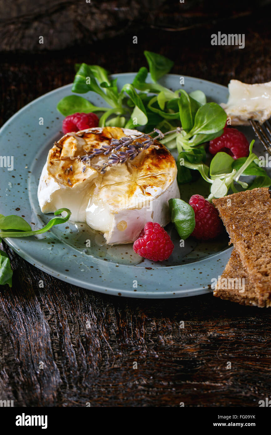 Baked Goat cheese with honey and raspberries Stock Photo - Alamy