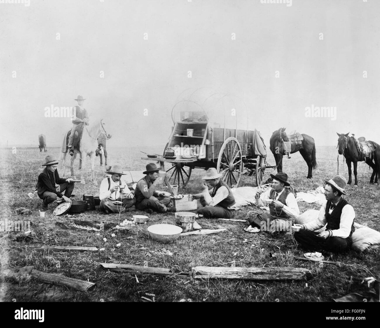 COWBOY CAMP, 1898. /nA group of cowboys eating beside the Irwin ...