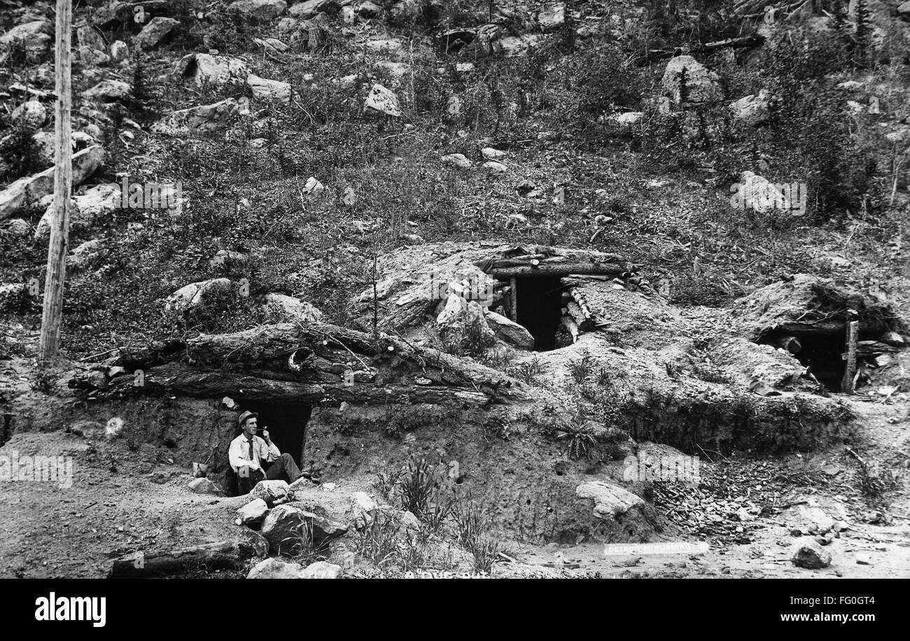 COLORADO: DUGOUT HOME. /nA man seated outside a dugout cabin at the ...
