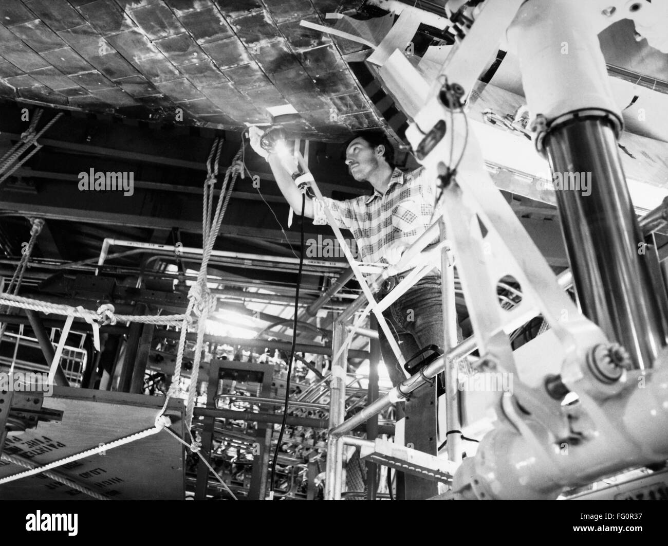 SPACE: SPACECRAFT, 1988. /nA NASA technician repairing thermal ...