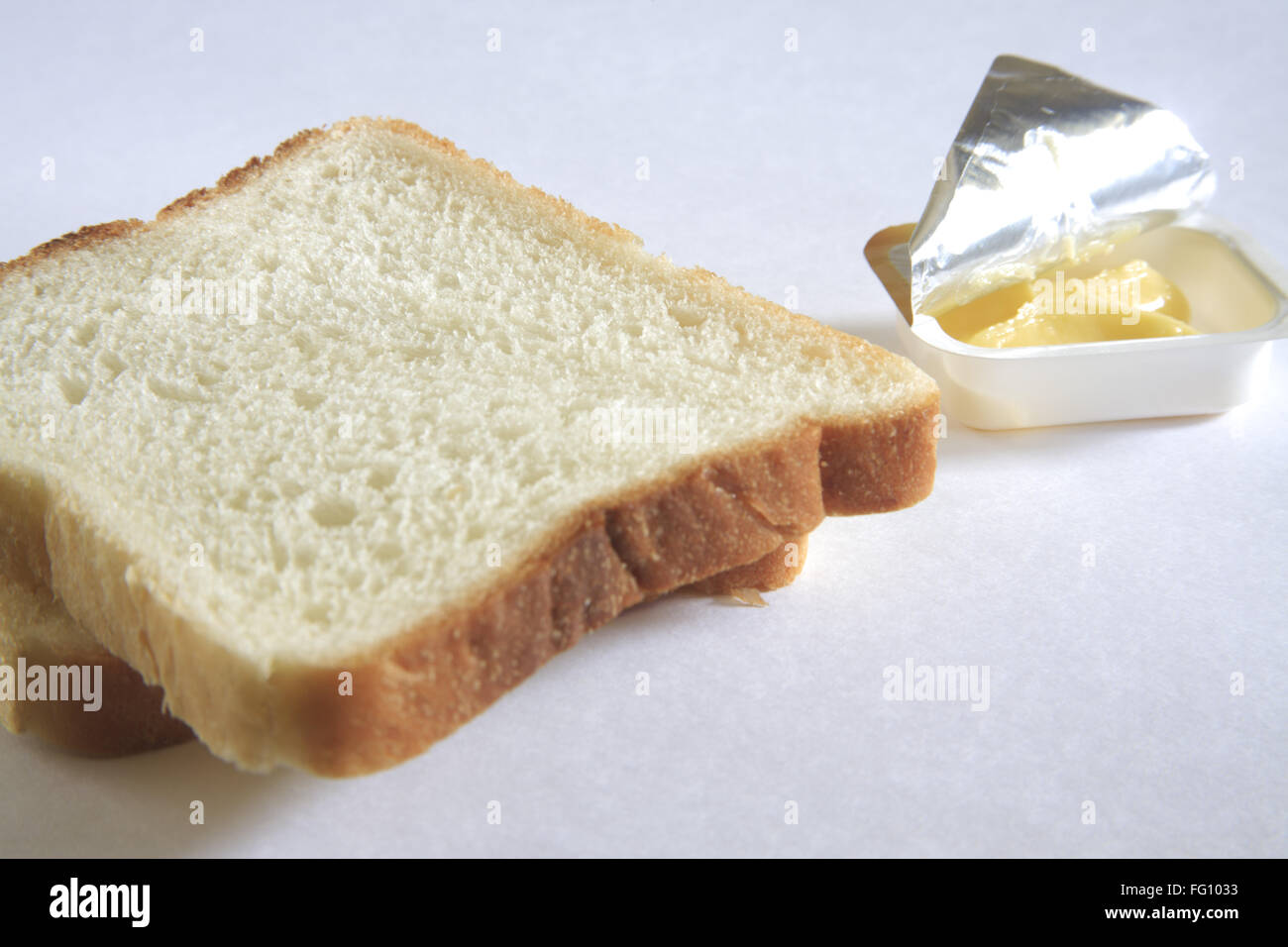 Breakfast , bread and butter in half open container on white background ...