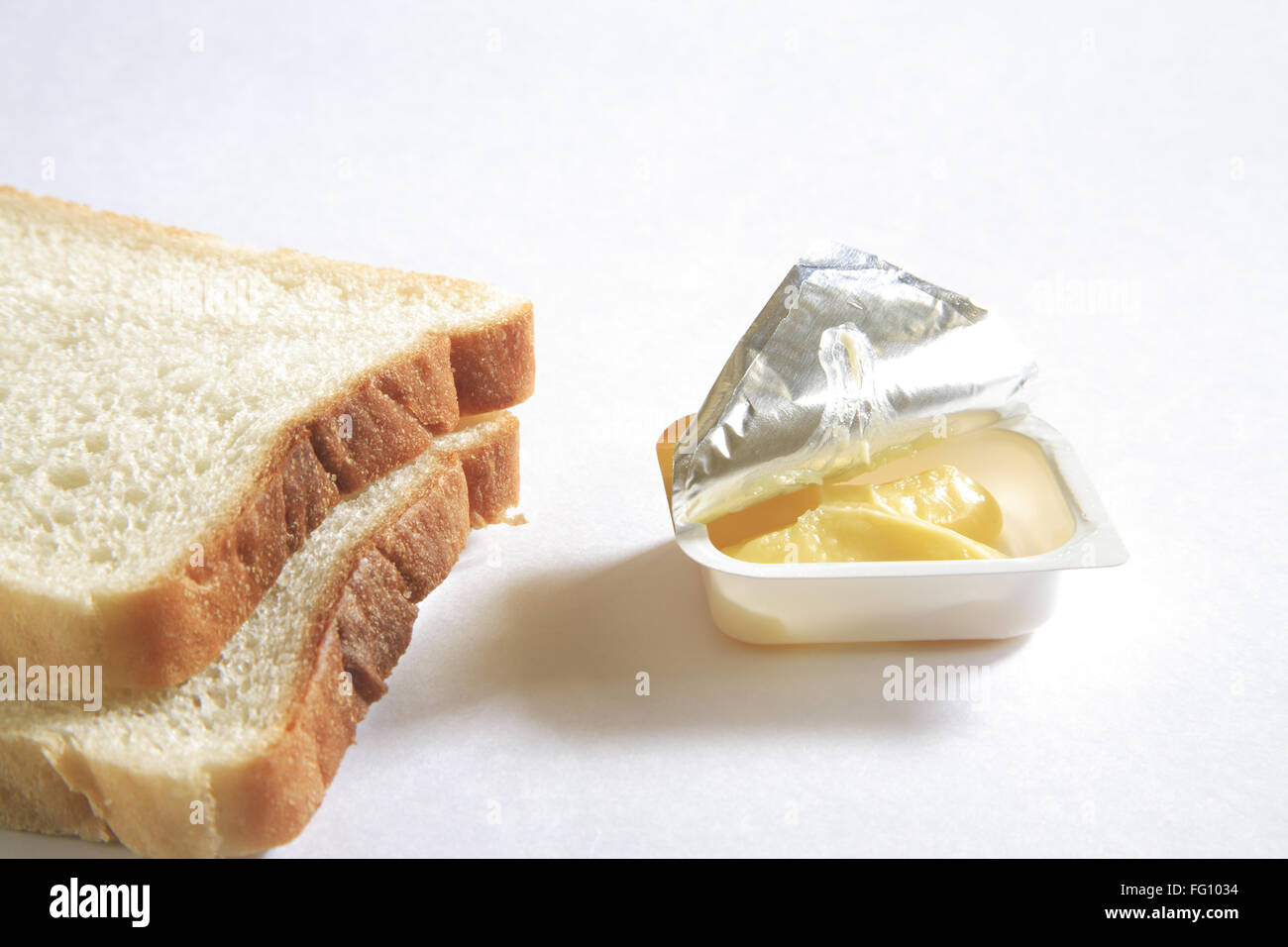 Breakfast , bread and butter in half open container on white background ...