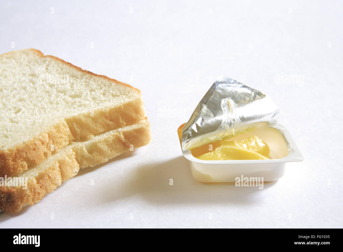 Breakfast , bread and butter in half open container on white background ...
