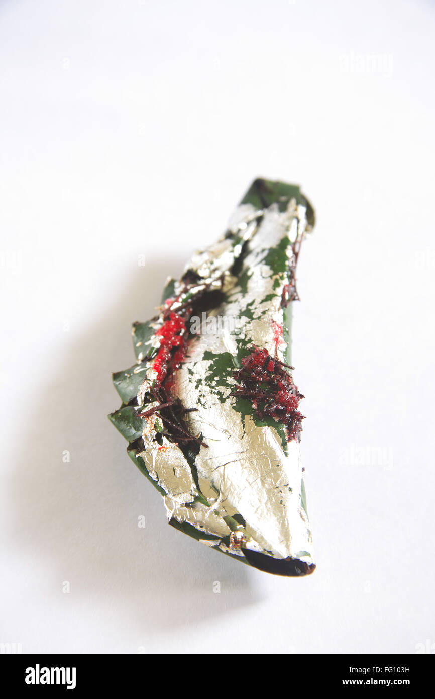 Gilouri pan prepared and folded in betel leaves on white background ...