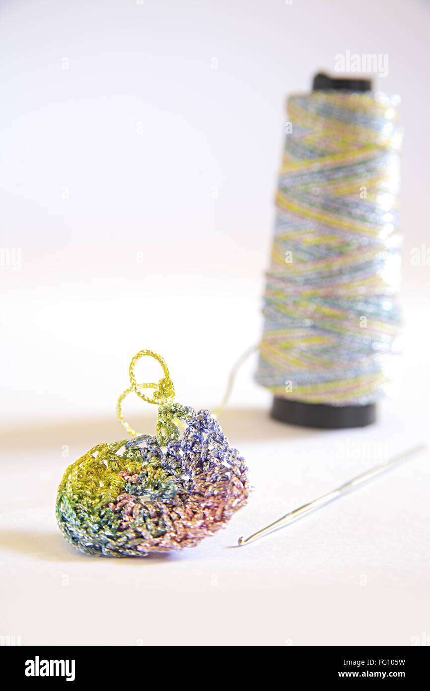 Concept , incomplete silky shiny thread and knitting hooked needle on ...