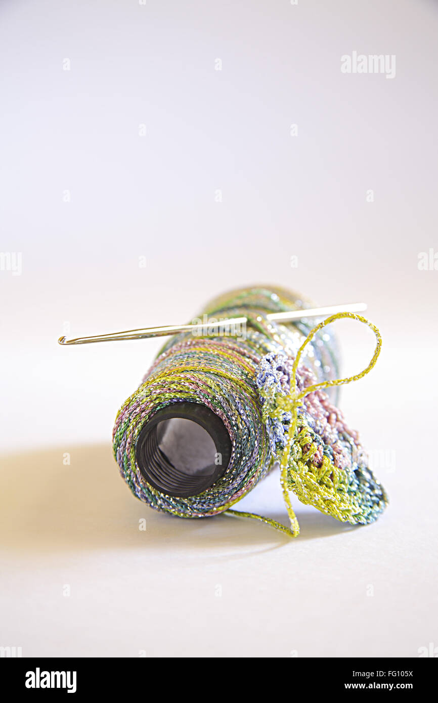 Concept , incomplete silky shiny thread and knitting hooked needle on ...