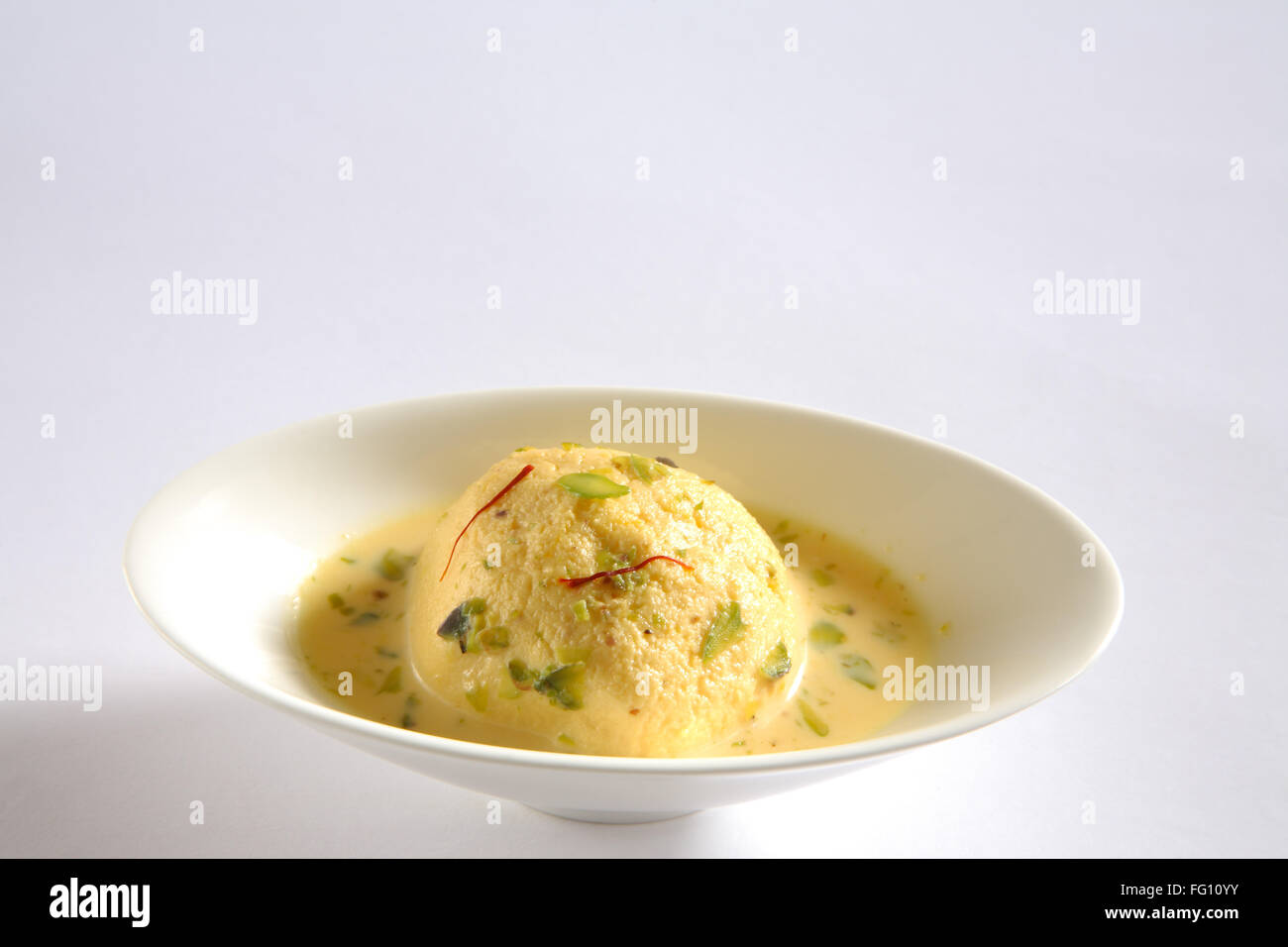 Indian sweet , kesar rasmalai garnish with pistachio and saffron served ...