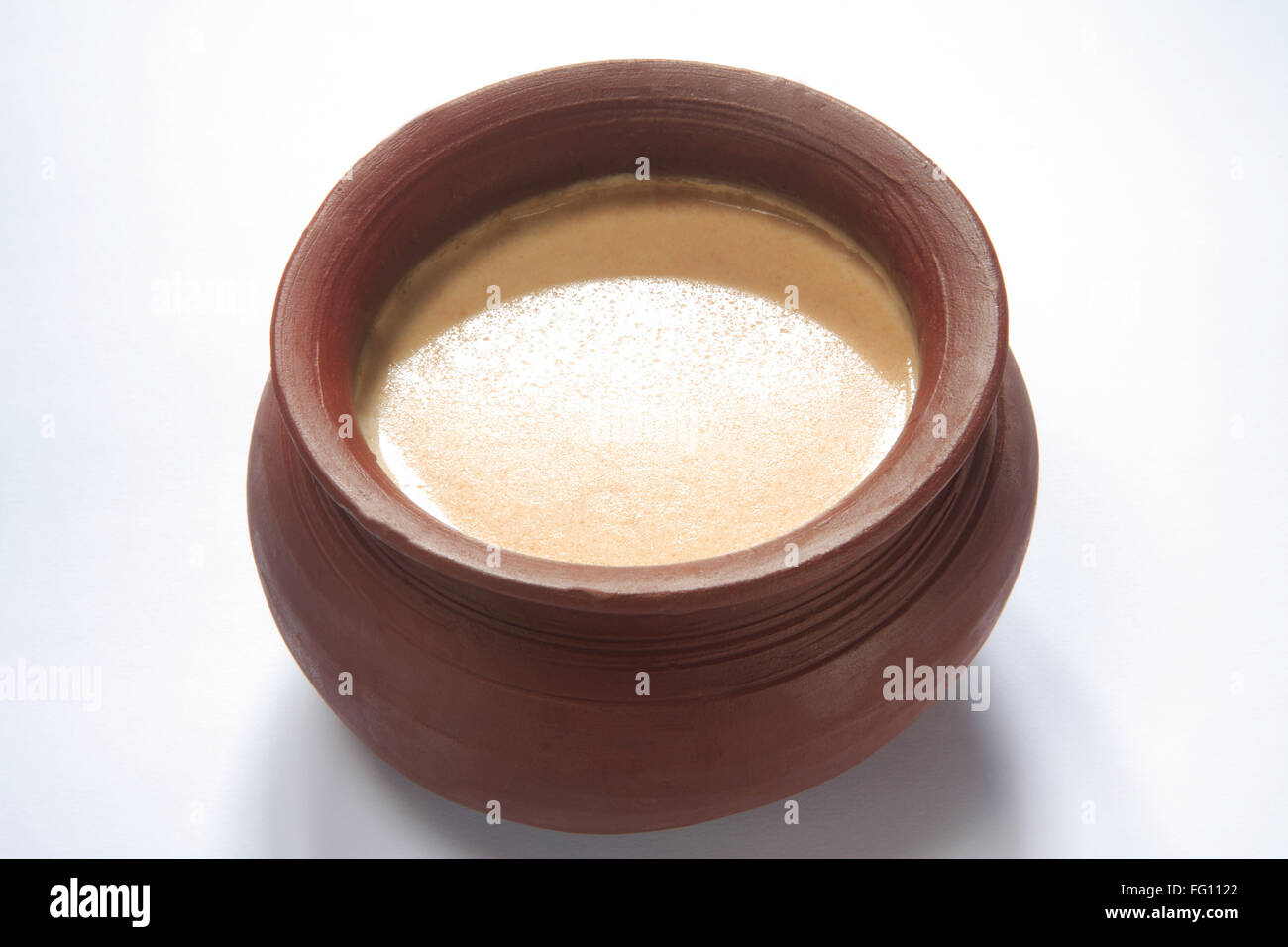 Indian sweet , mishti doi bengali mithai in earthen pot on white ...