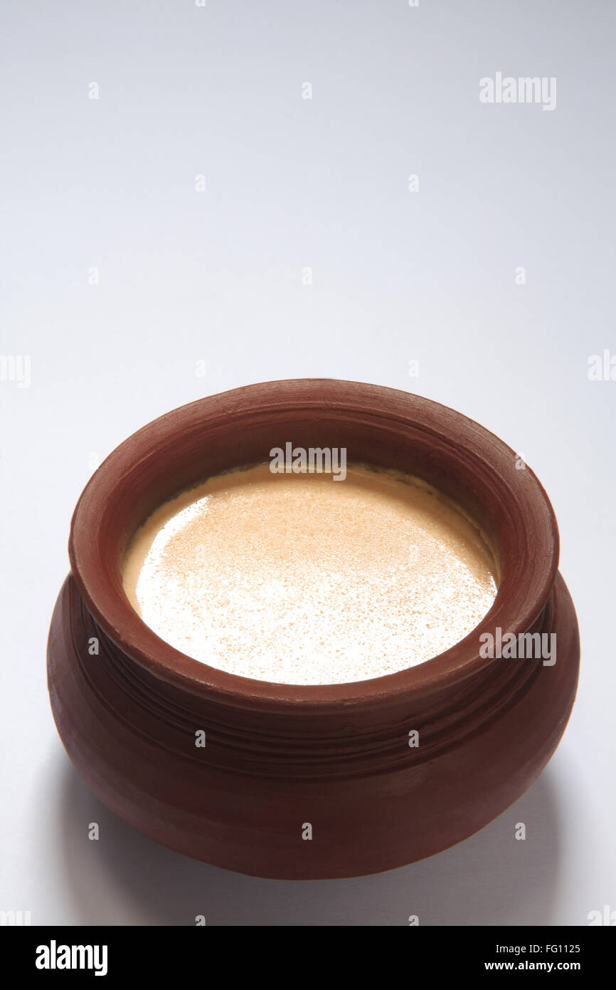 Indian sweet , mishti doi bengali mithai in earthen pot on white ...