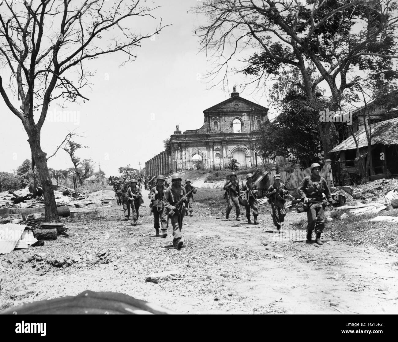 WWII: PHILIPPINES, 1945. /nAmerican troops marching through the town of ...