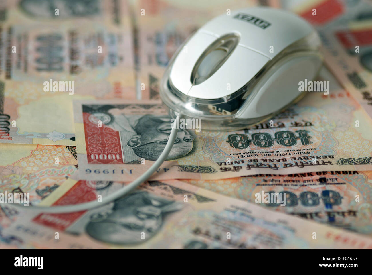 Computer mouse on Indian currency thousand rupee notes of share market ...