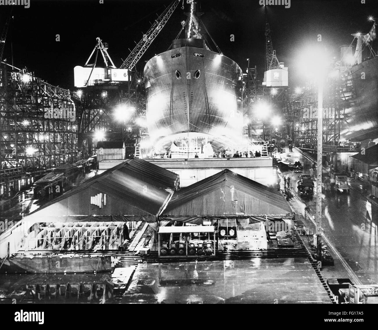 WWII: SHIPYARDS, 1942. /nA nighttime view of a ship being built at the ...