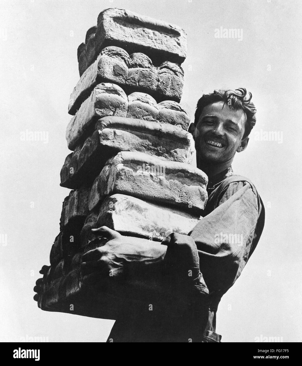 WWII: SOLDIER, c1943. /nAn American soldier carrying loaves of bread in ...