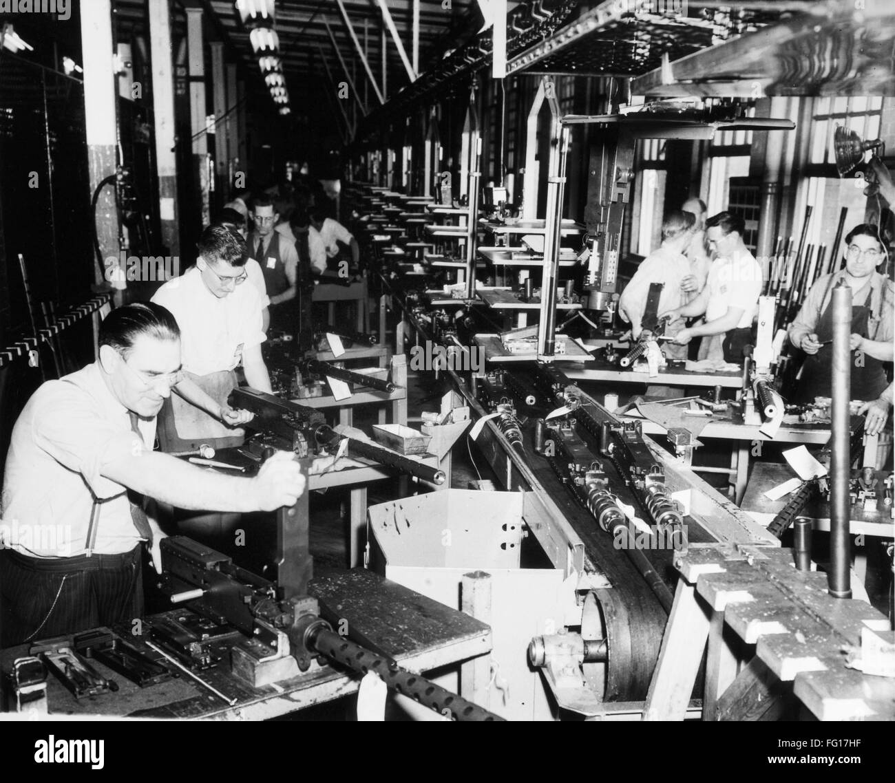 WWII: FACTORY, 1942. /nMen working on machine guns on the assembly line ...