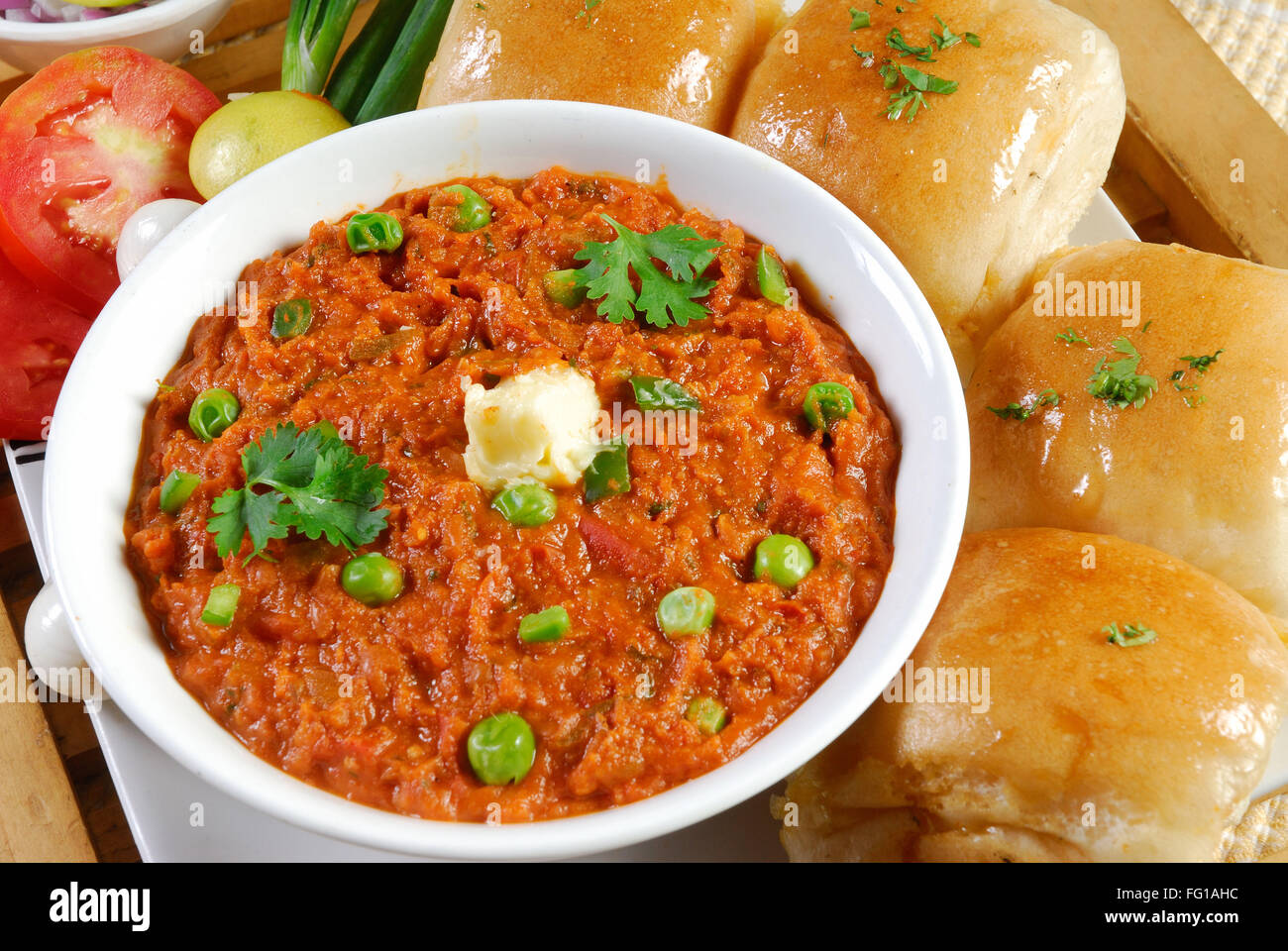 Vegetarian food , pav bhaji decorated with butter and green peas served ...
