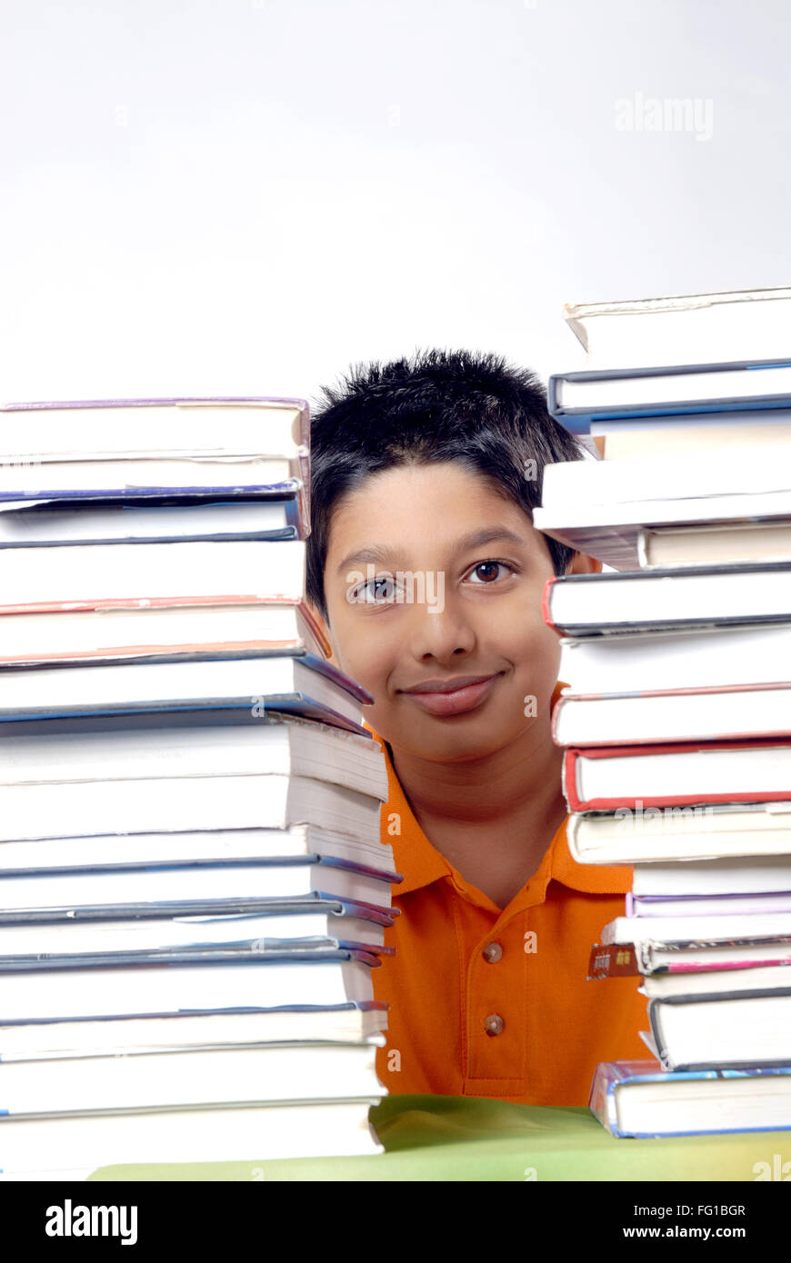 Boy looking through stack of books MR#152 Stock Photo - Alamy