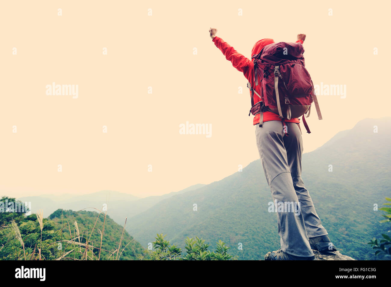 cheering young woman hiker open arms on mountain peak Stock Photo - Alamy